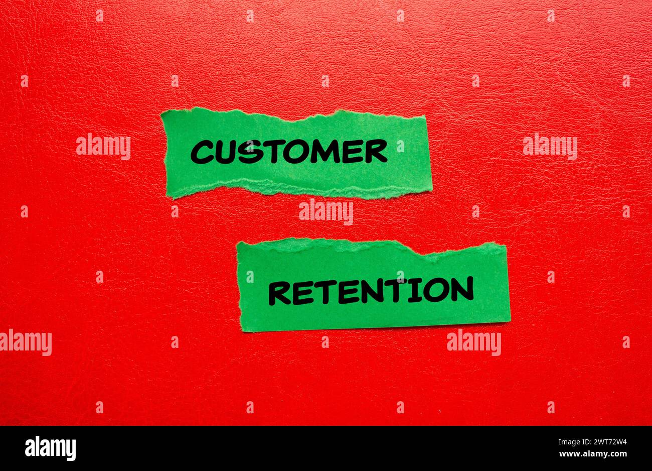 Customer retention words written on green torn paper pieces with red ...
