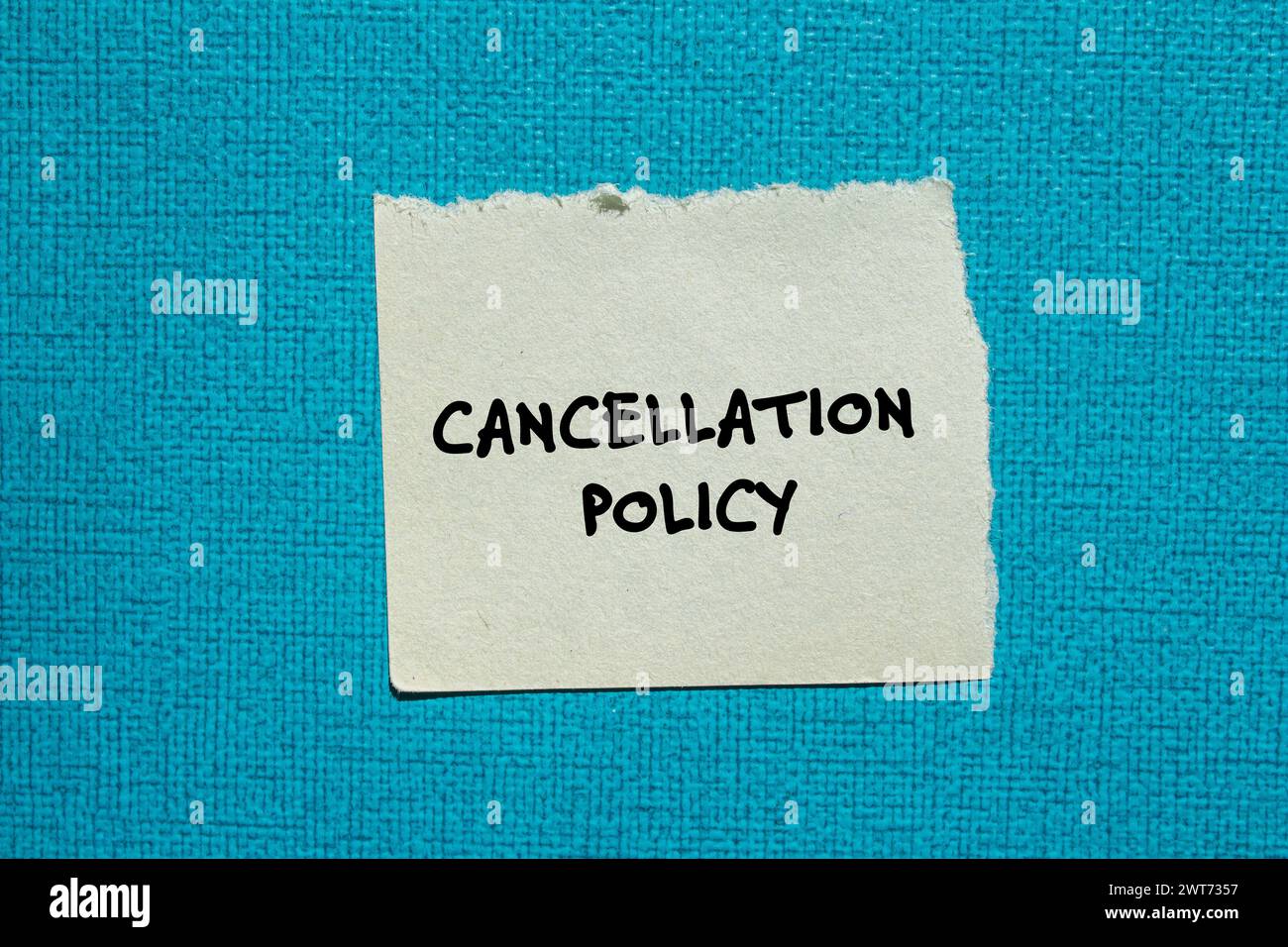 Cancellation policy words written on torn paper piece with blue ...