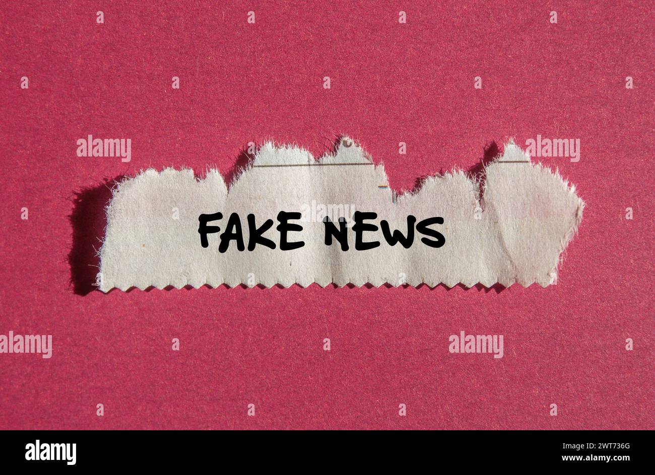 Fake news words written on white torn newspaper piece with red ...