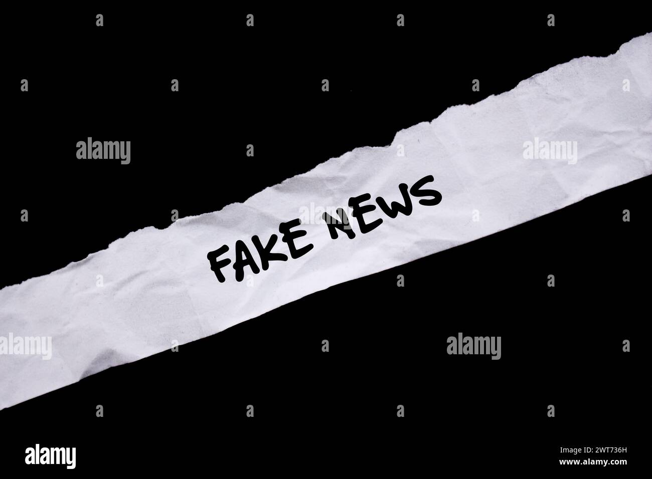 Fake news words written on white torn paper with black background ...