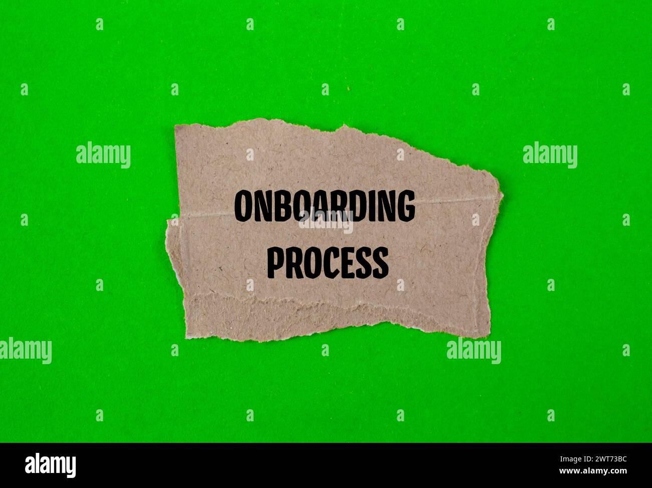Onboarding process words written on torn paper piece with green ...