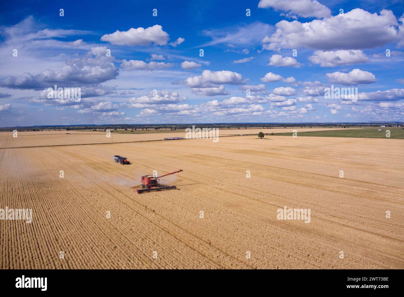 Aerial of combine harvester unloading into a bin chaser harvested wheat ...