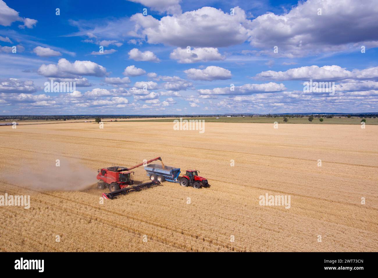 Aerial of combine harvester unloading into a bin chaser harvested wheat ...