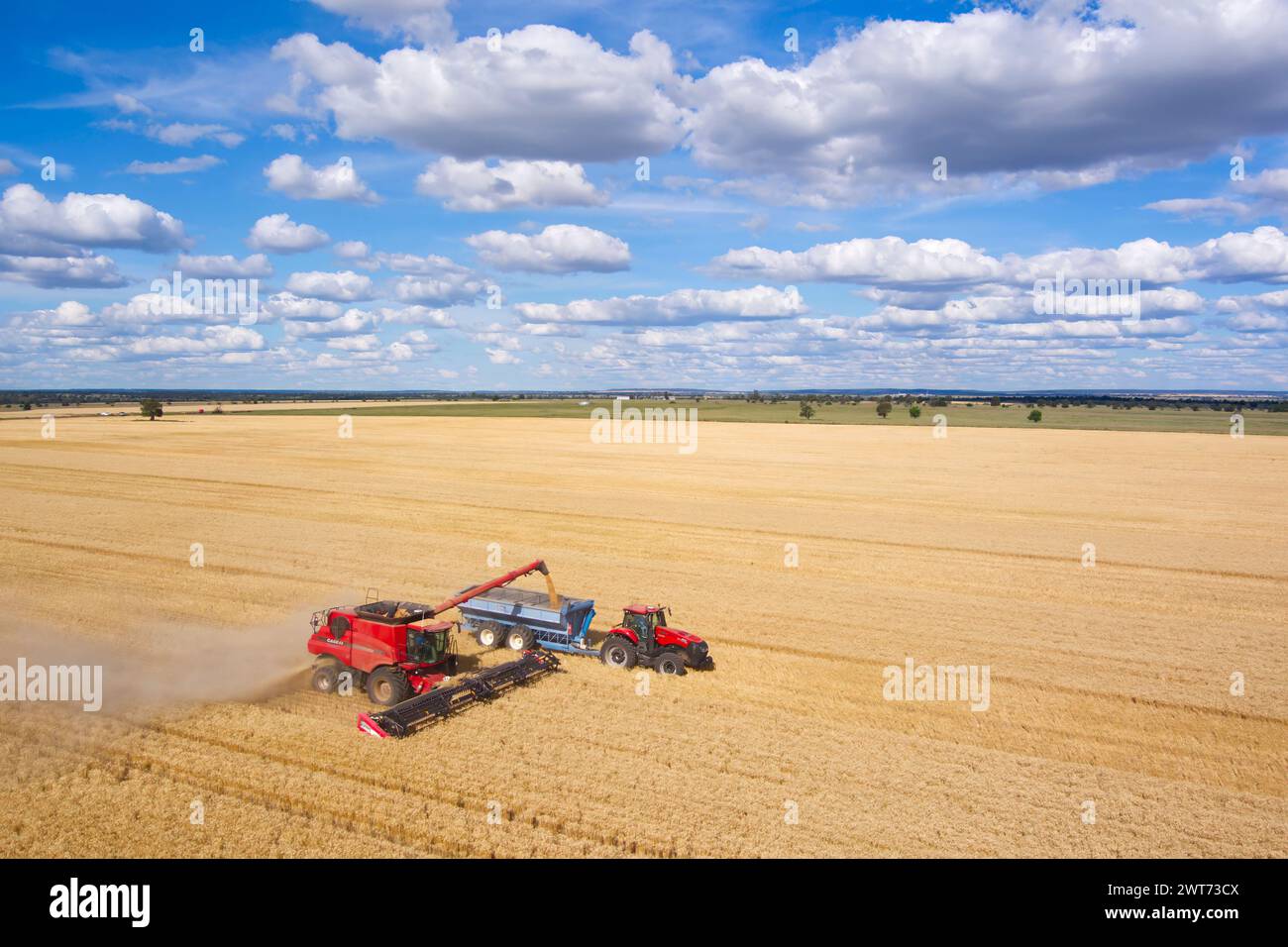 Aerial of combine harvester unloading into a bin chaser harvested wheat ...