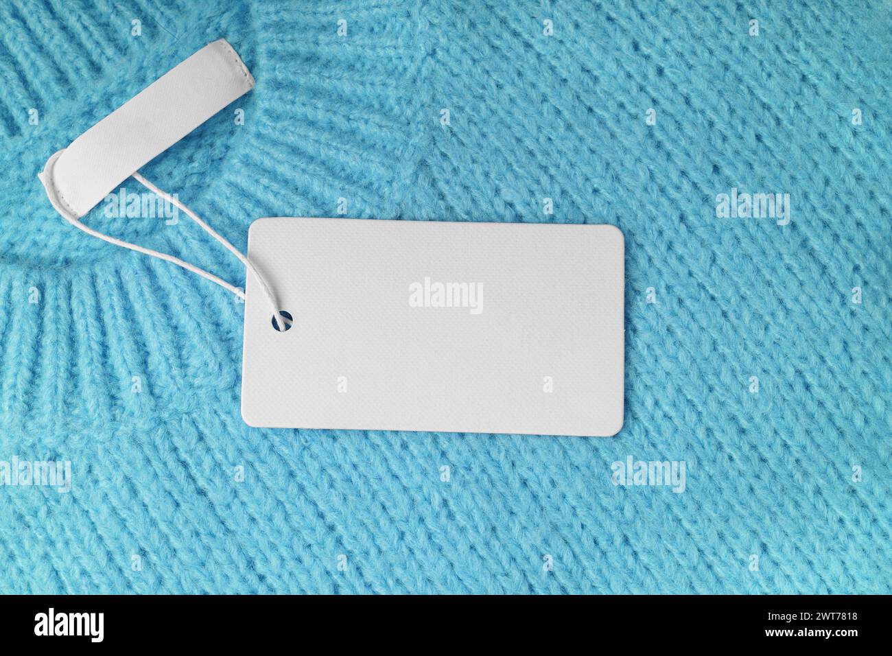 Blank clothing tag and inner label on neck of turquoise knitted sweater ...