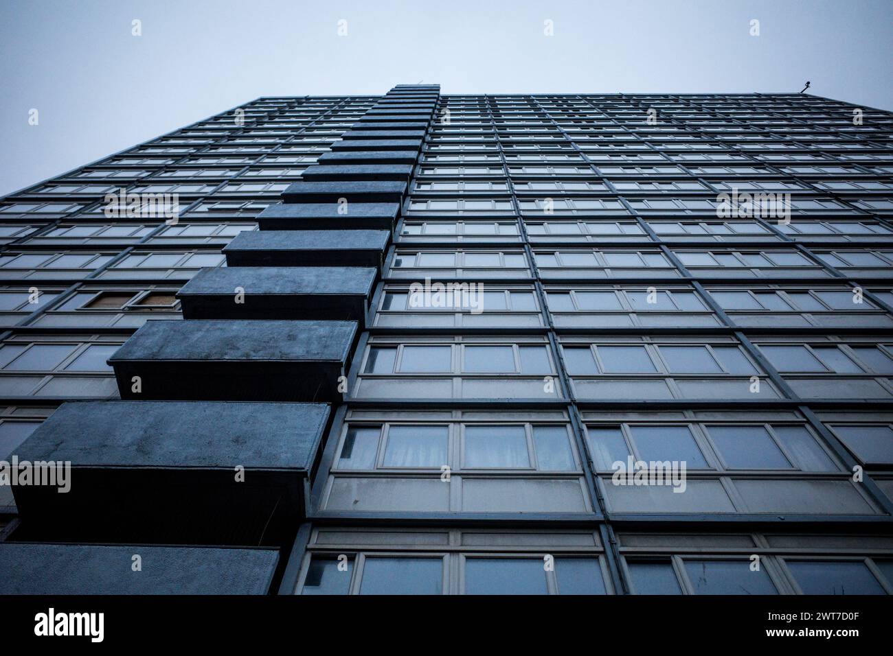 View of run down tower block looking upwards showing windows and ...