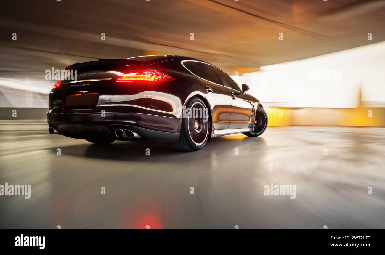 brown Porsche Panamera Turbo driving inside parking garage. Motion shot ...
