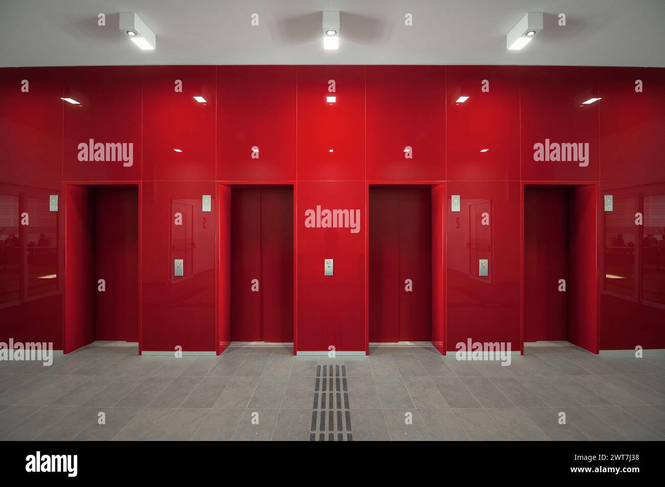 Four elevator doors in a red wall. Two dimensional image of gloss red ...