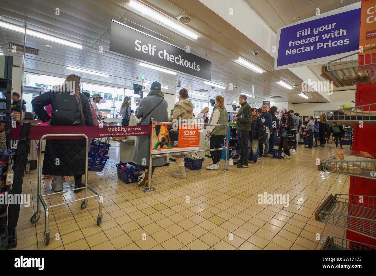 London, UK 16 March 2024 . Long queues of shoppers at the self ...