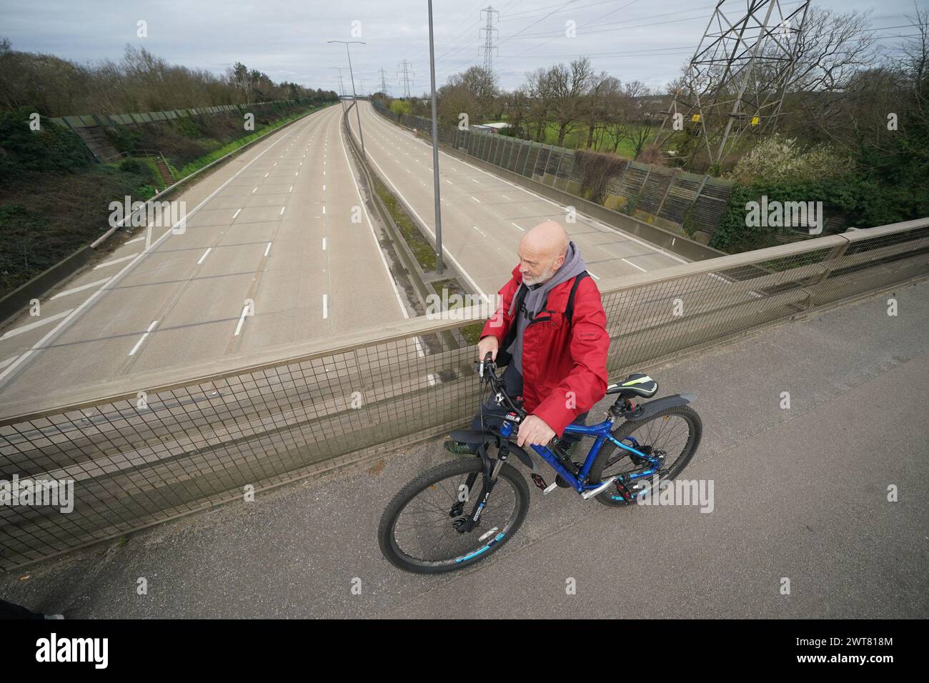 A man walks across the Parvis Road bridge in Byfleet, that crosses over ...