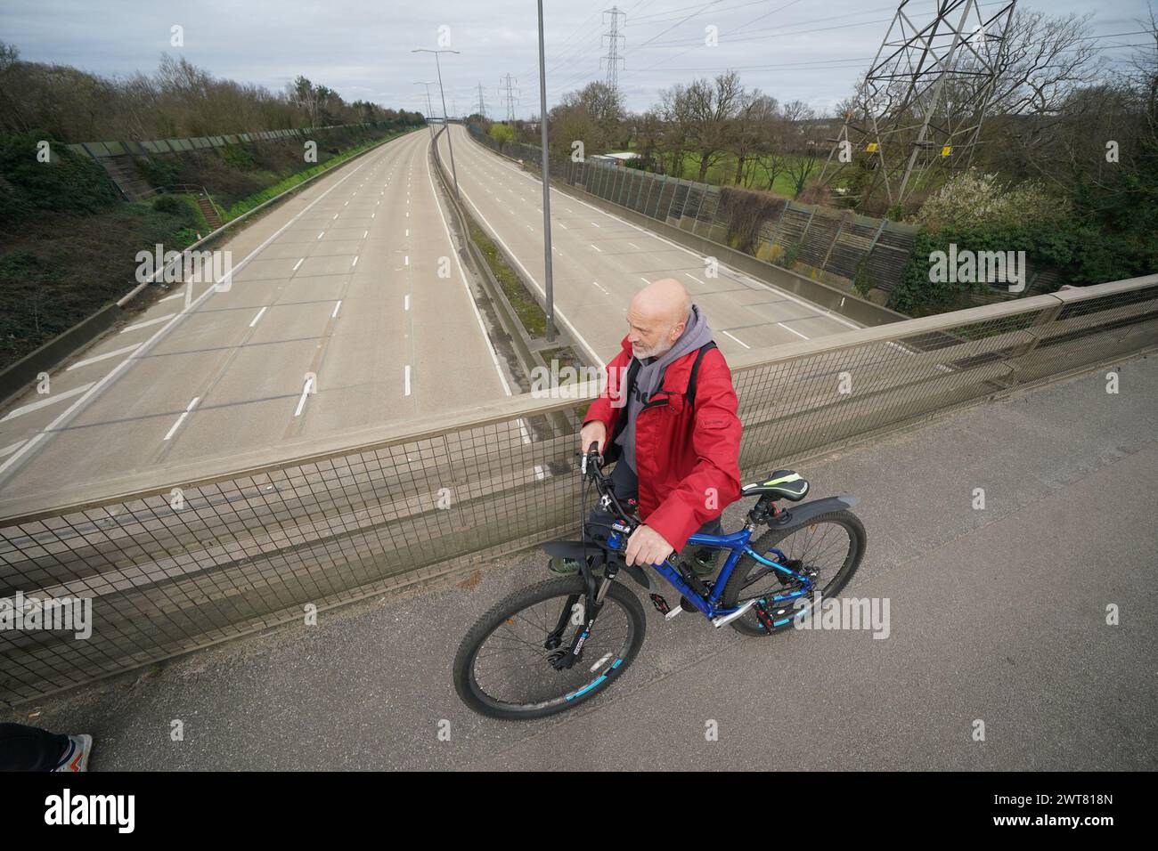 A man walks across the Parvis Road bridge in Byfleet, that crosses over ...