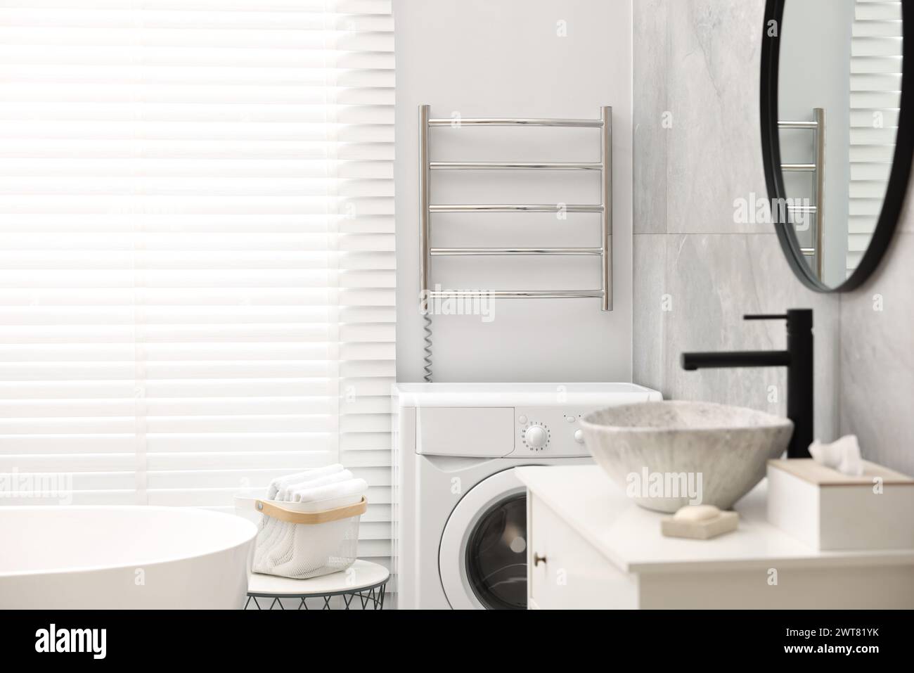 Stylish bathroom interior with heated towel rail and modern washing ...