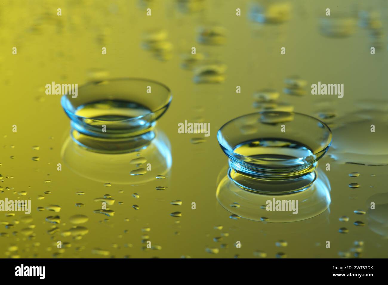 Pair of contact lenses on wet mirror surface Stock Photo - Alamy