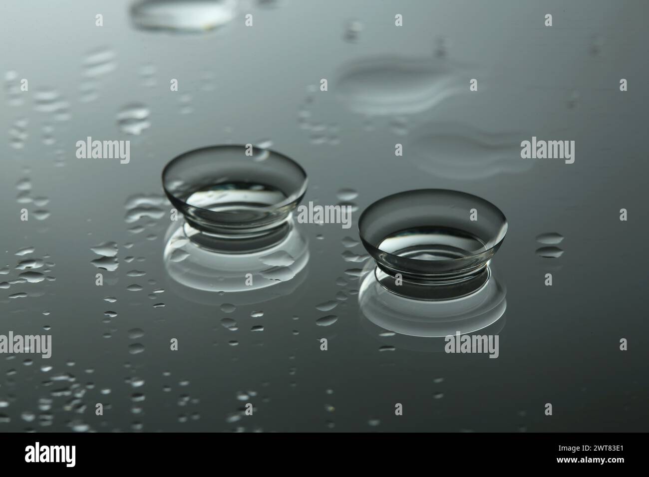 Pair of contact lenses on wet mirror surface Stock Photo - Alamy