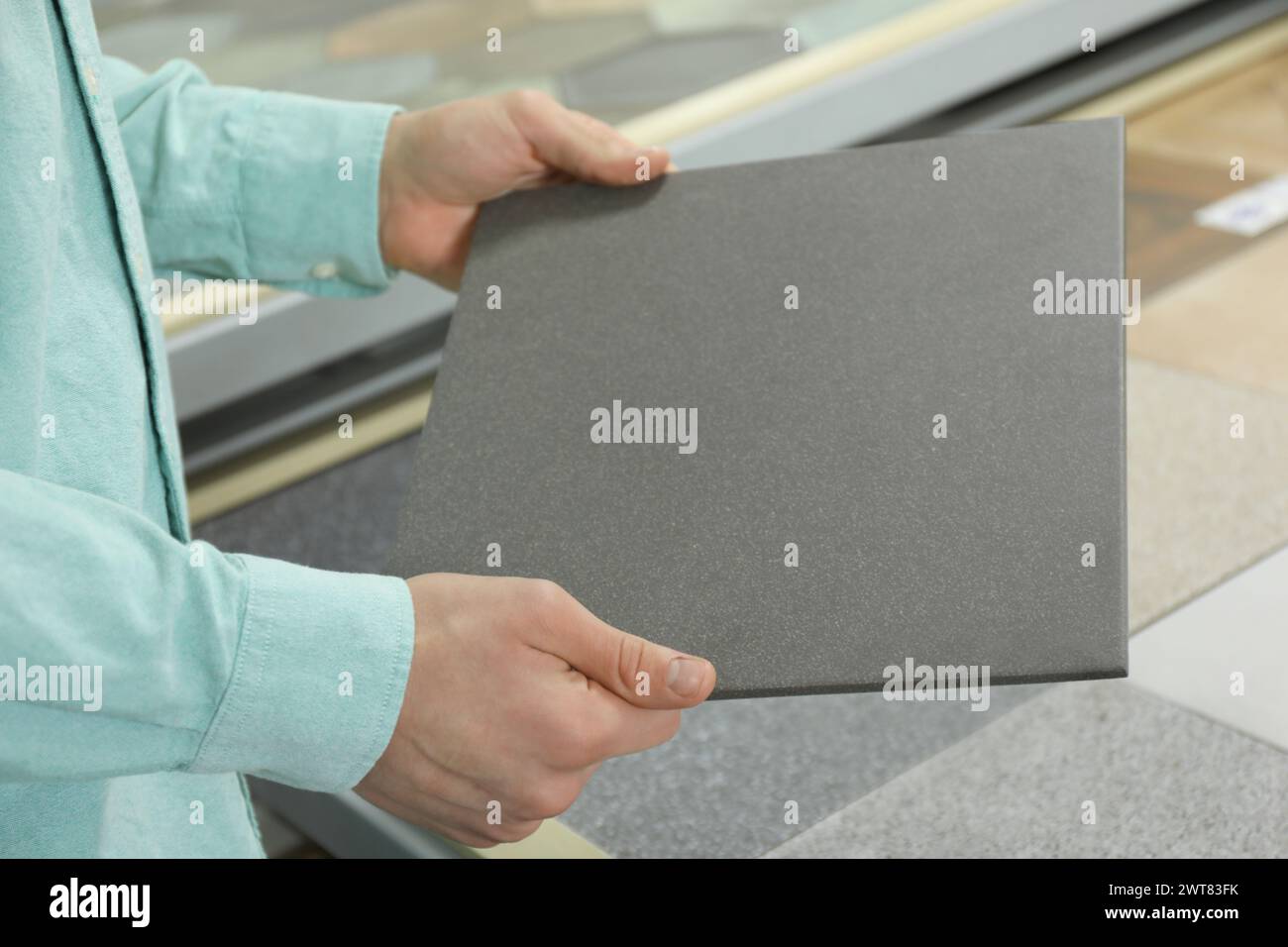 Man holding tile sample in store, closeup Stock Photo - Alamy