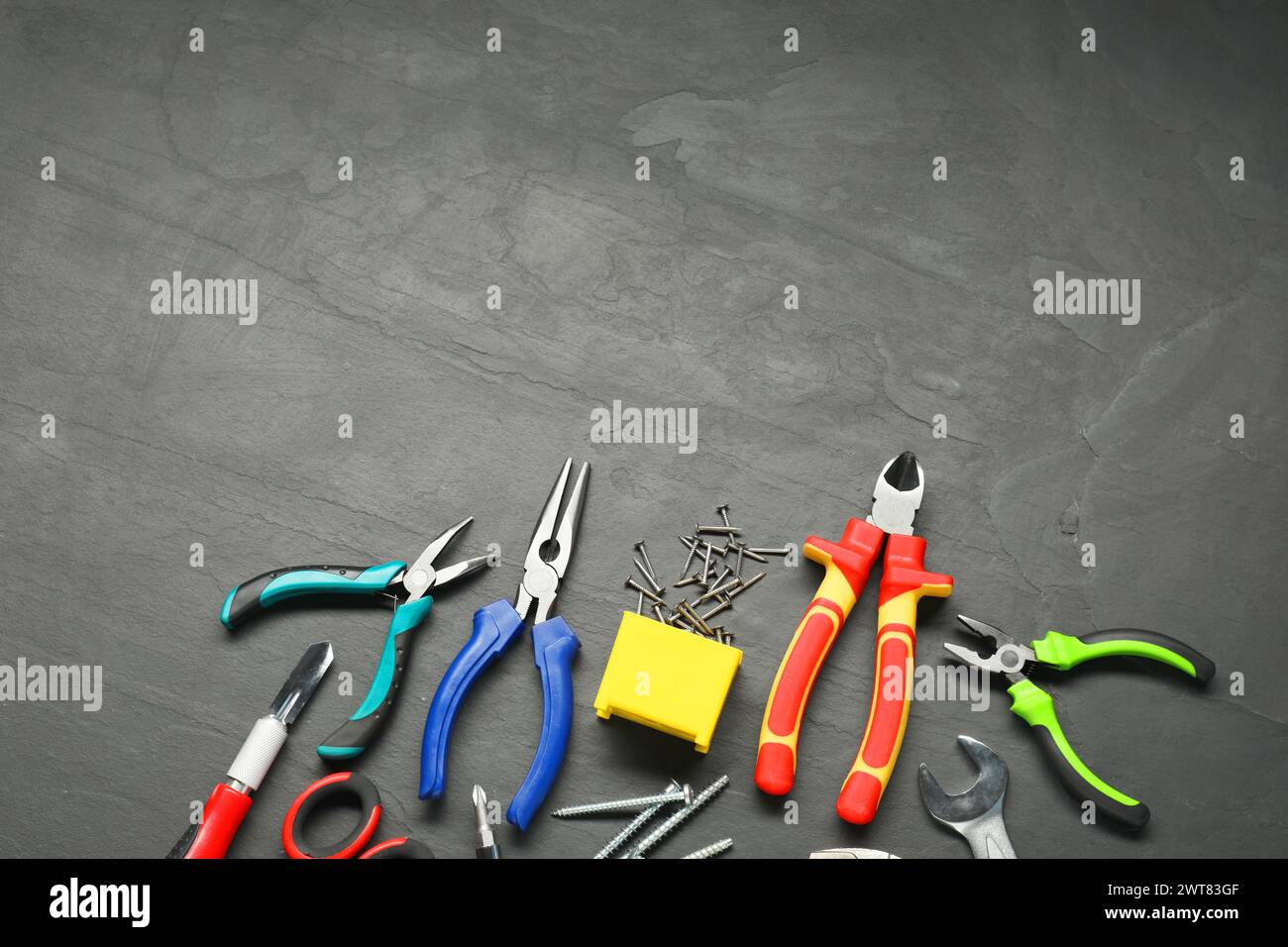 Different pliers, wrench, nails and other repair tools on black ...