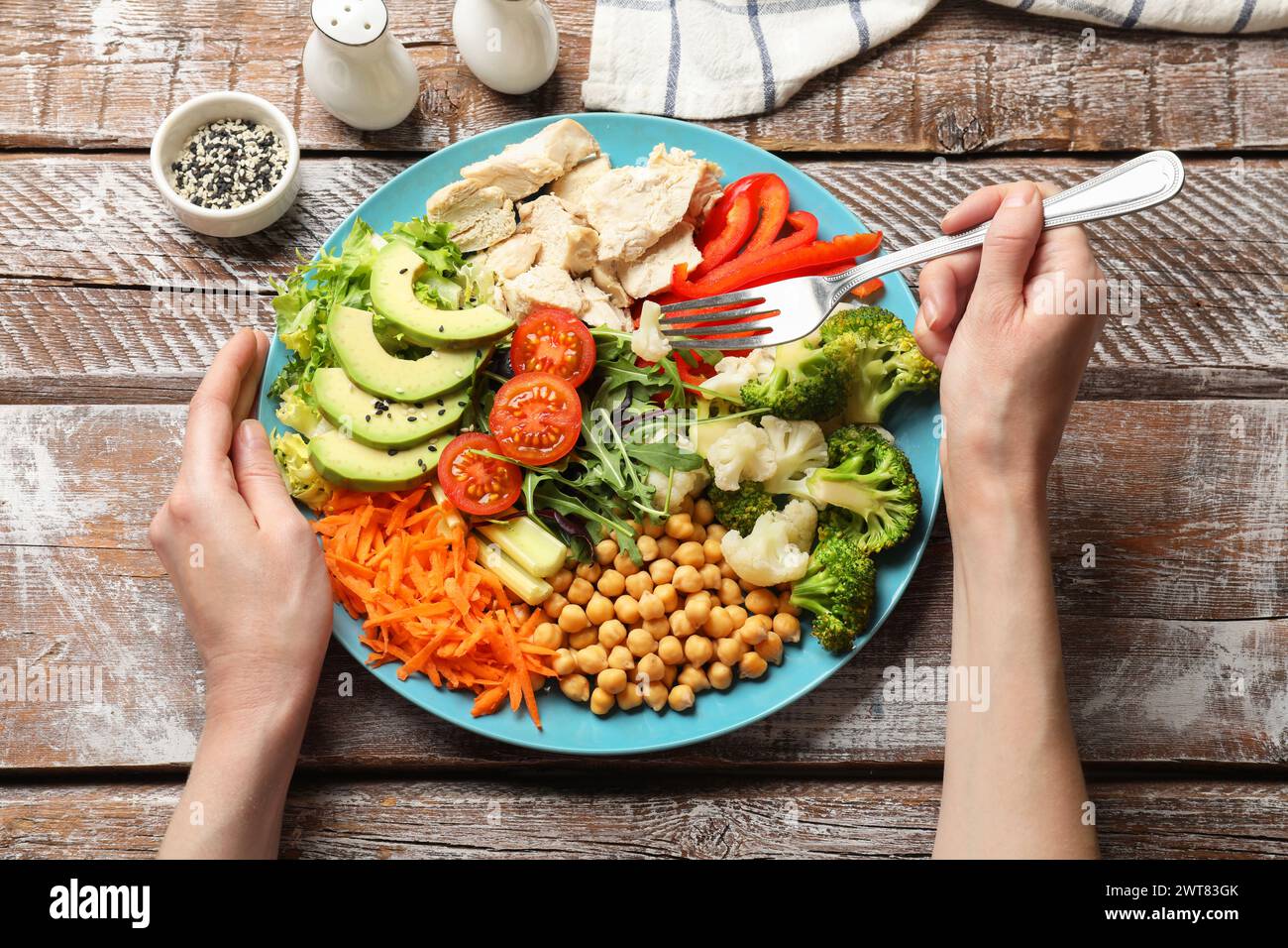 Balanced diet and healthy foods. Woman eating dinner at wooden table ...