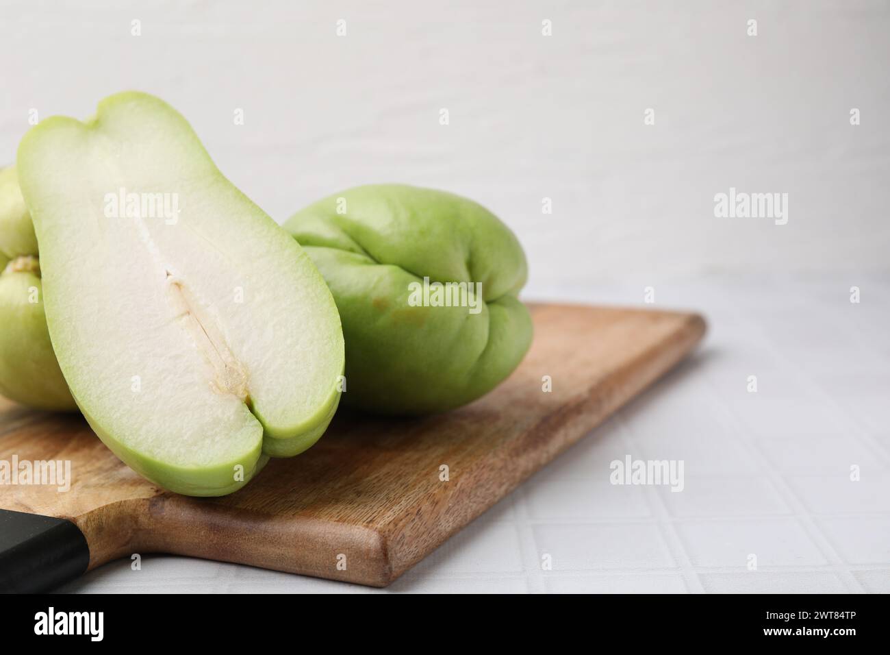 Cut and whole chayote on white tiled table, closeup Stock Photo - Alamy