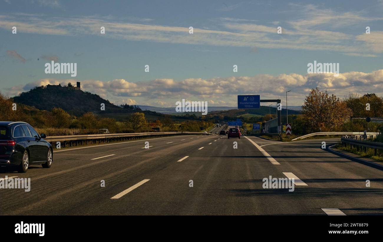 Blue road signs and cars on the autumn German Autobahn at sunny day ...