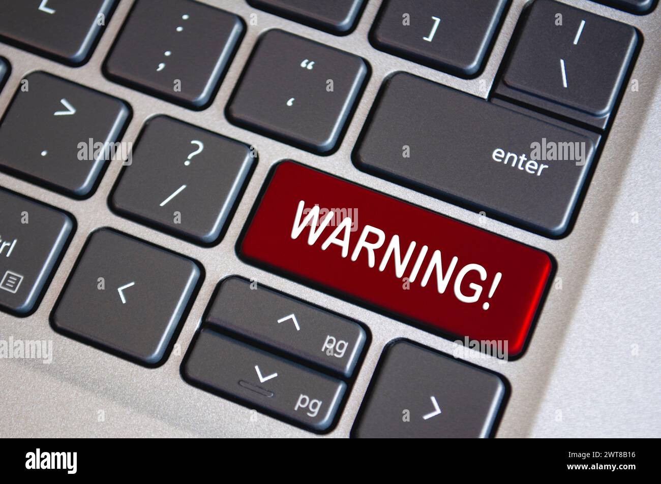 Warning text on dark red laptop keyboard. Security and warning concept ...