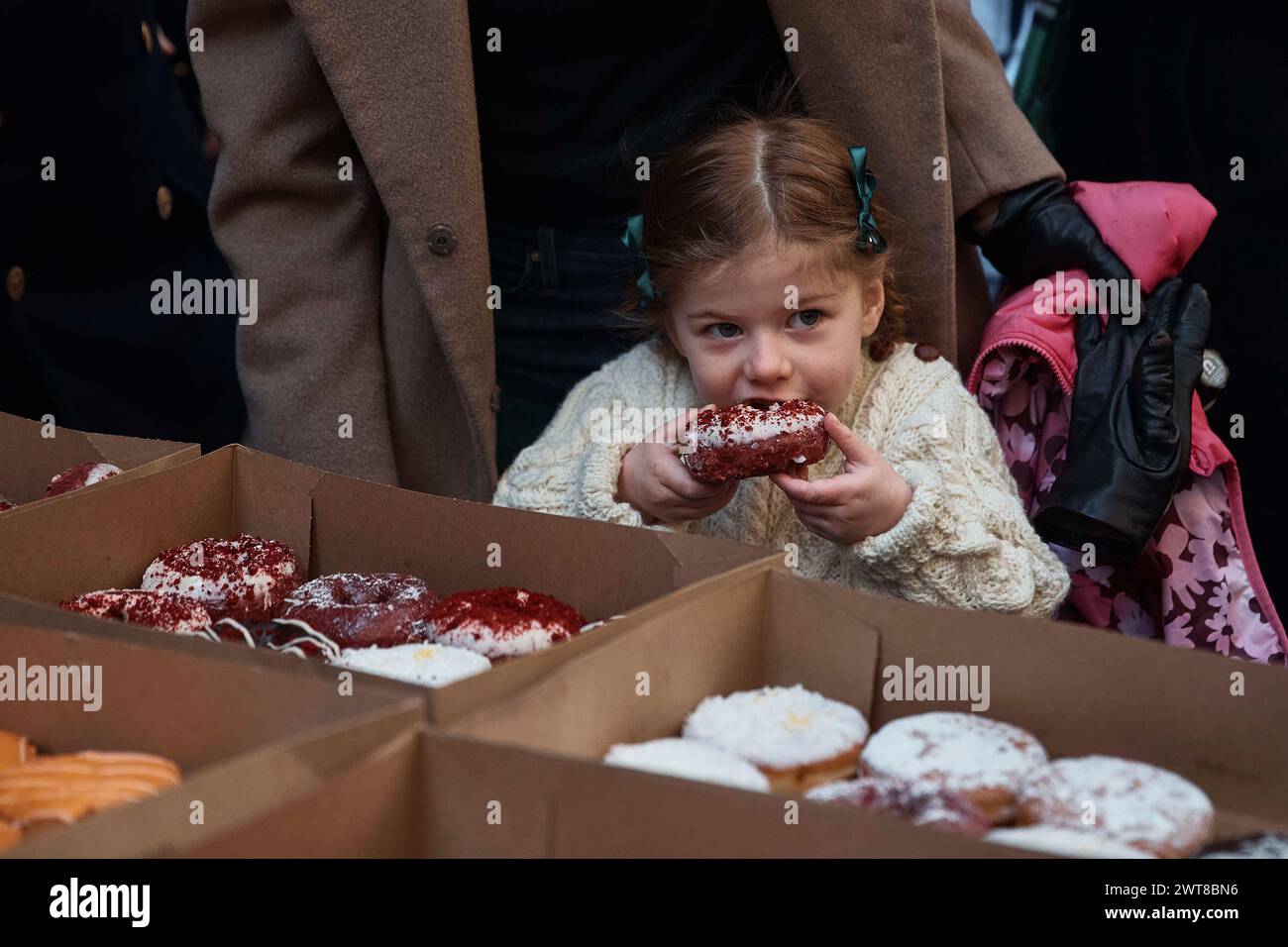 A child eats a donut during the St. Patrick's Day Parade on Saturday ...