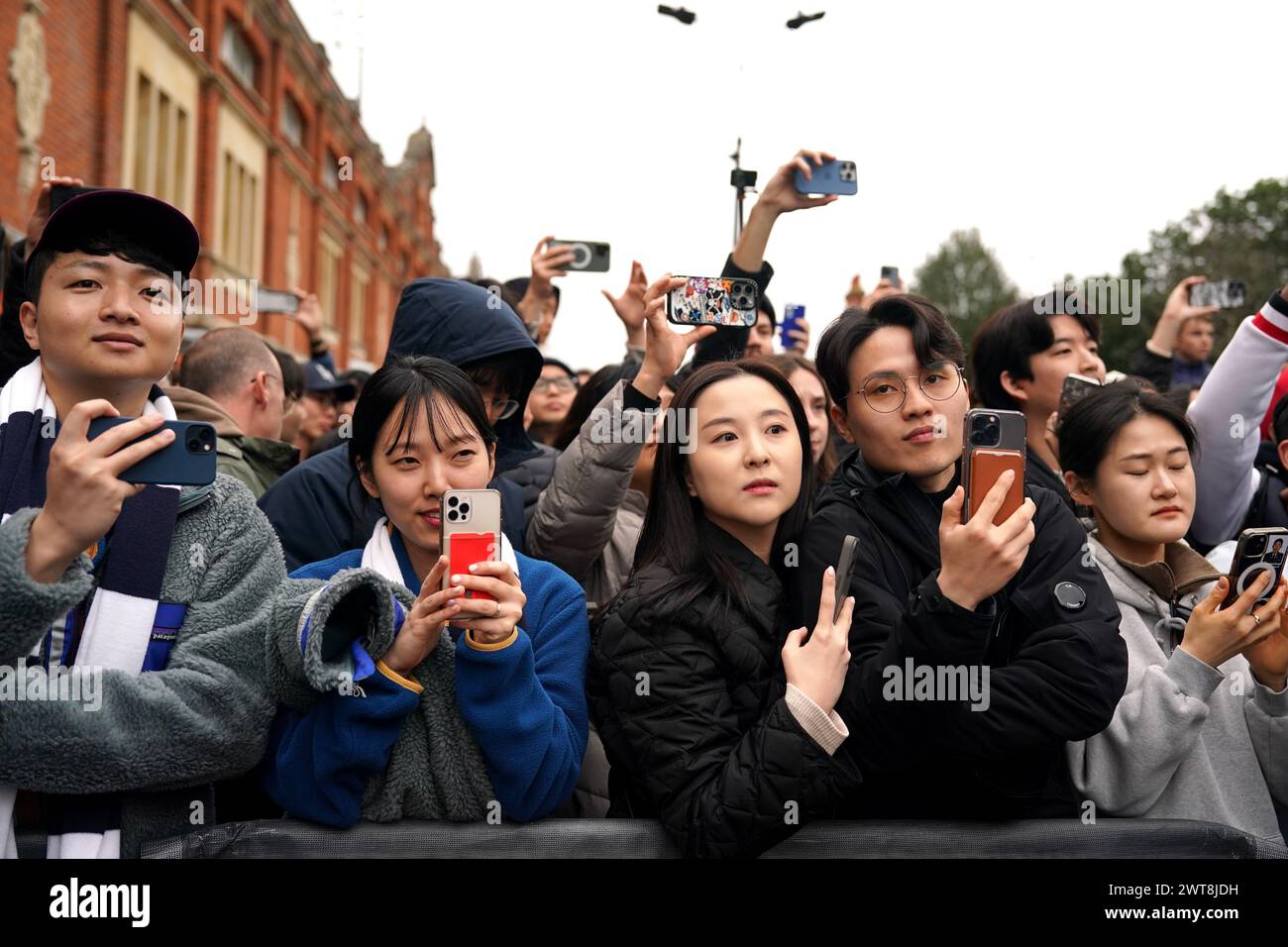 Tottenham Hotspur fans await the team coach outside the stadium ahead ...
