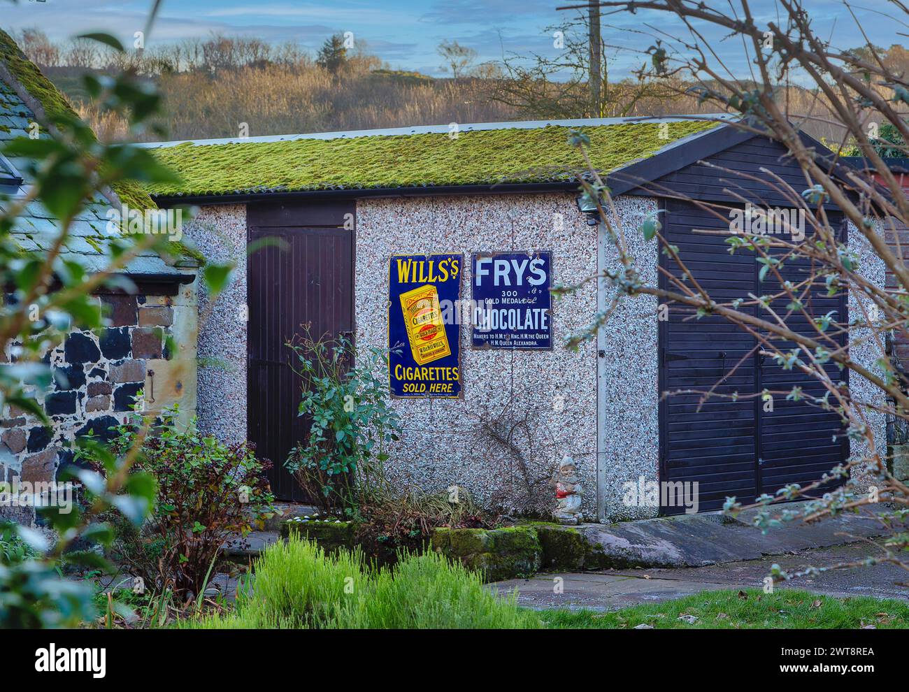 Vintage advertising signs on the side of a rural garage in England ...
