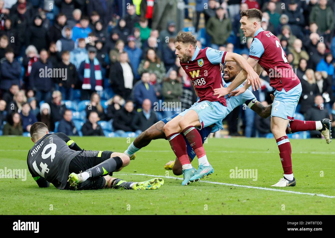 Burnley goalkeeper Arijanet Muric (left) saves at the feet of Brentford ...