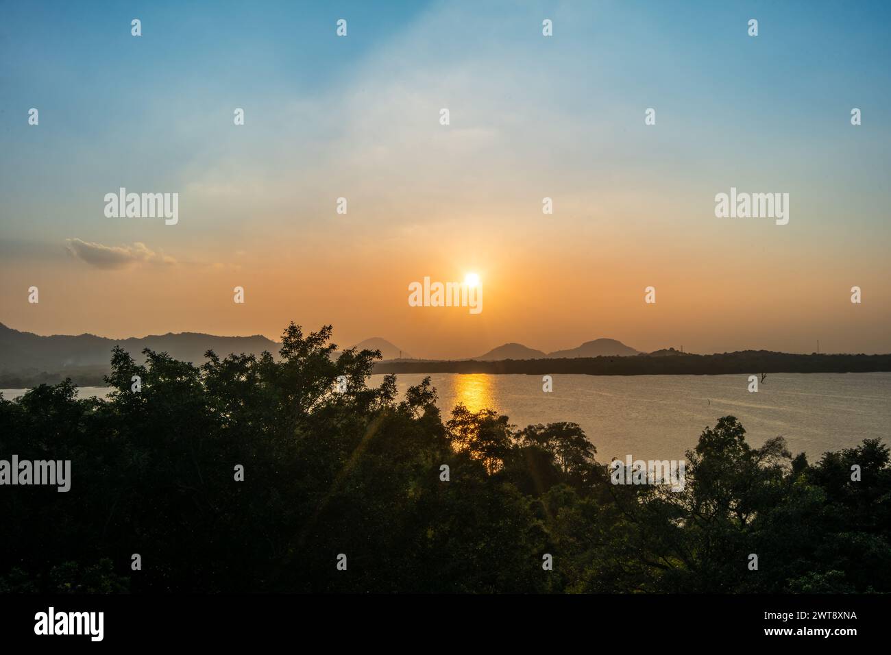 A mesmerizing view of the sunset over a lake, surrounded by mountains ...