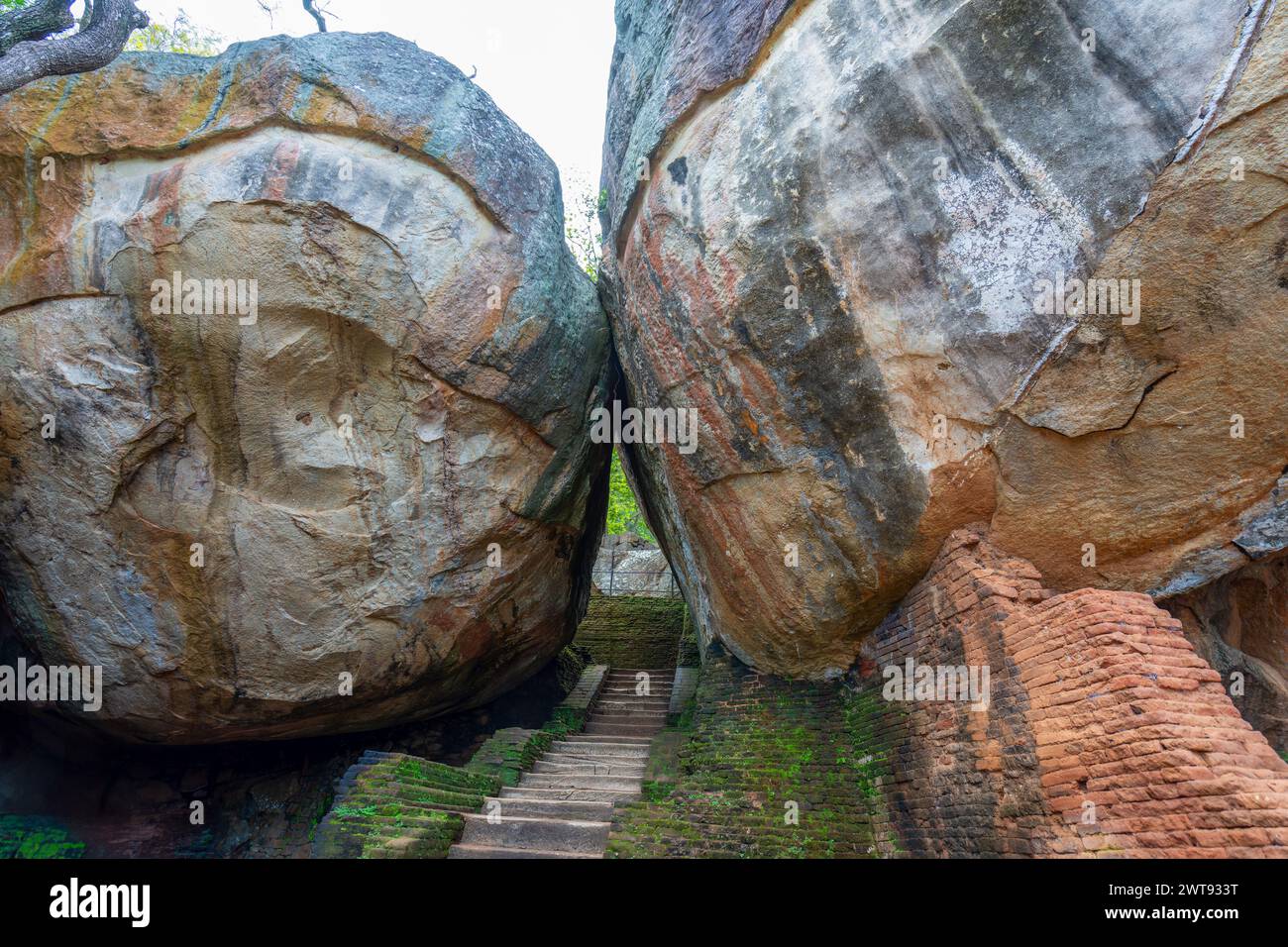 Tourists navigating the crevice between two large rocks at the exit of ...