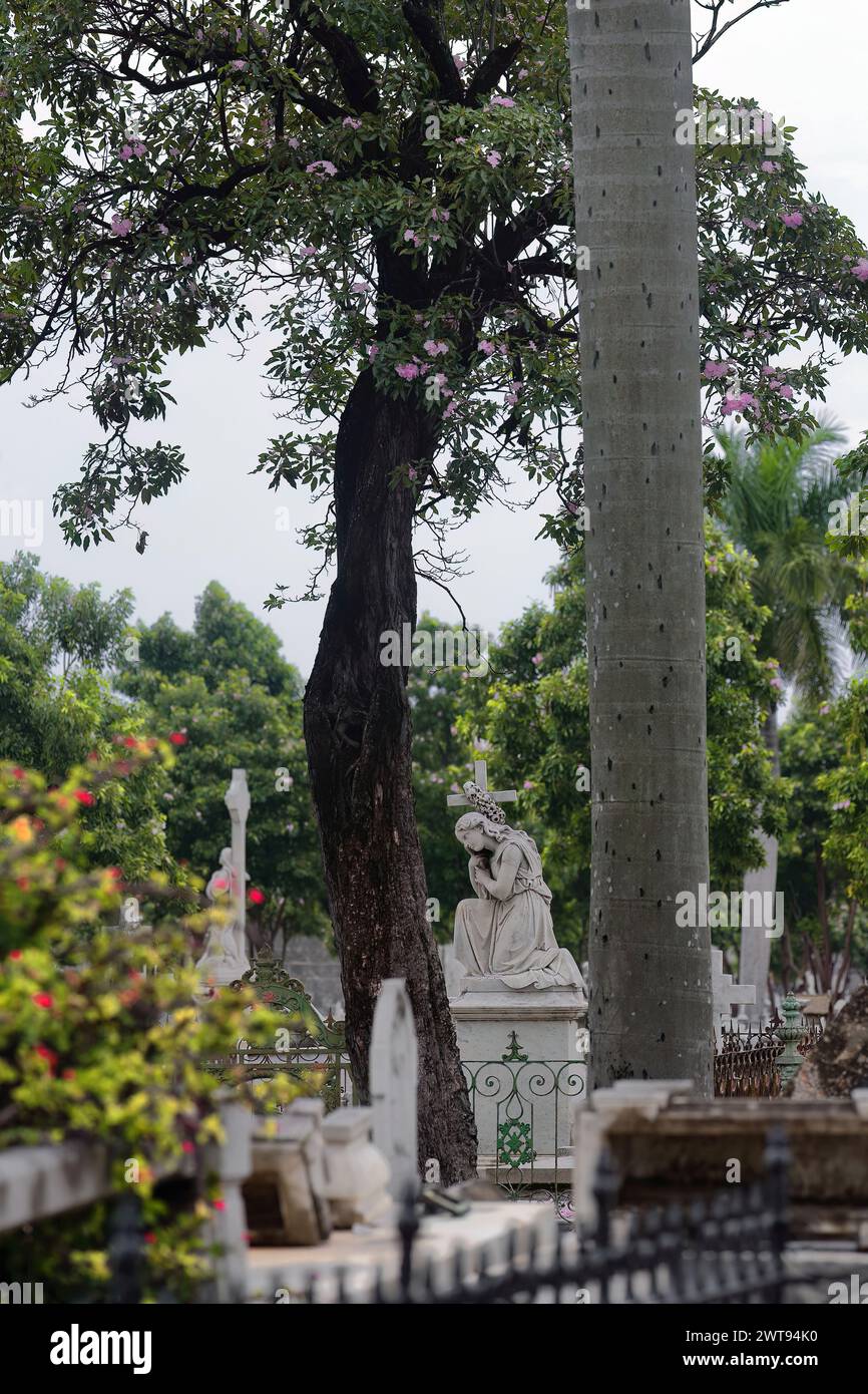 089 Marble statue of a nice young woman kneeling while hugging a cross atop an imposing grave in ...