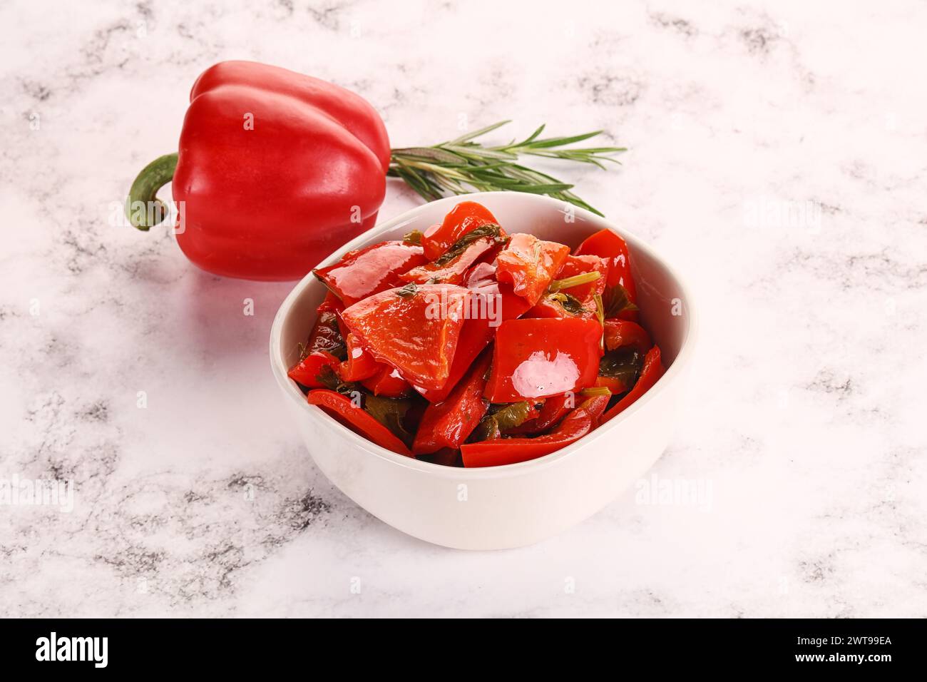 Pickled red bell pepper with herbs in the bowl Stock Photo - Alamy