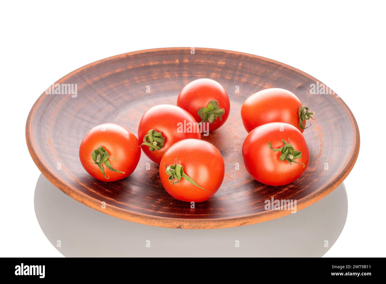Several ripe cherry tomatoes on a clay plate, macro, isolated on white background Stock Photo ...