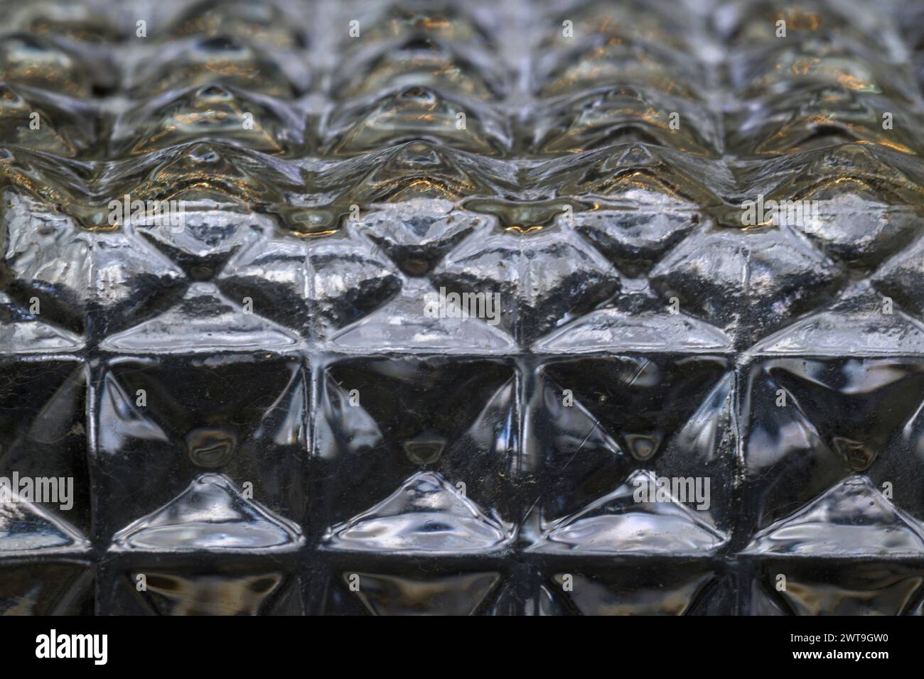 Detail of edge of glass liquor bottle carved square hexagons ...