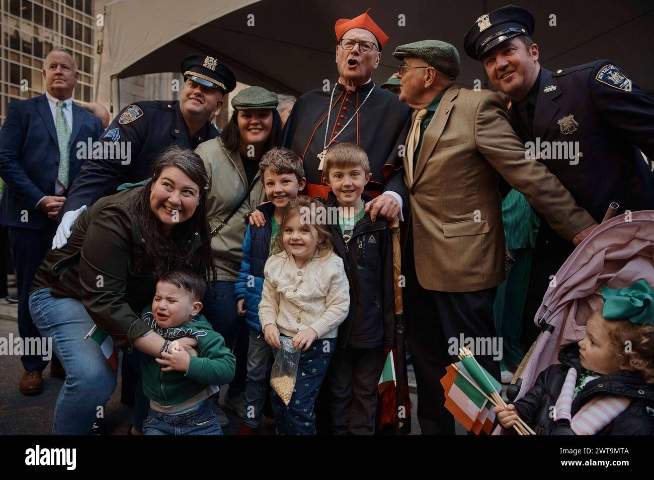 A child, bottom, second left, cries as people pose for a photo with ...