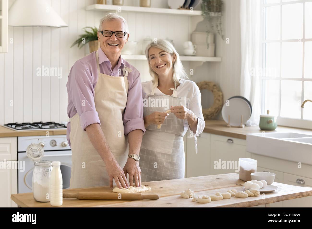 Beautiful middle-aged woman in apron cooking with senior father Stock ...