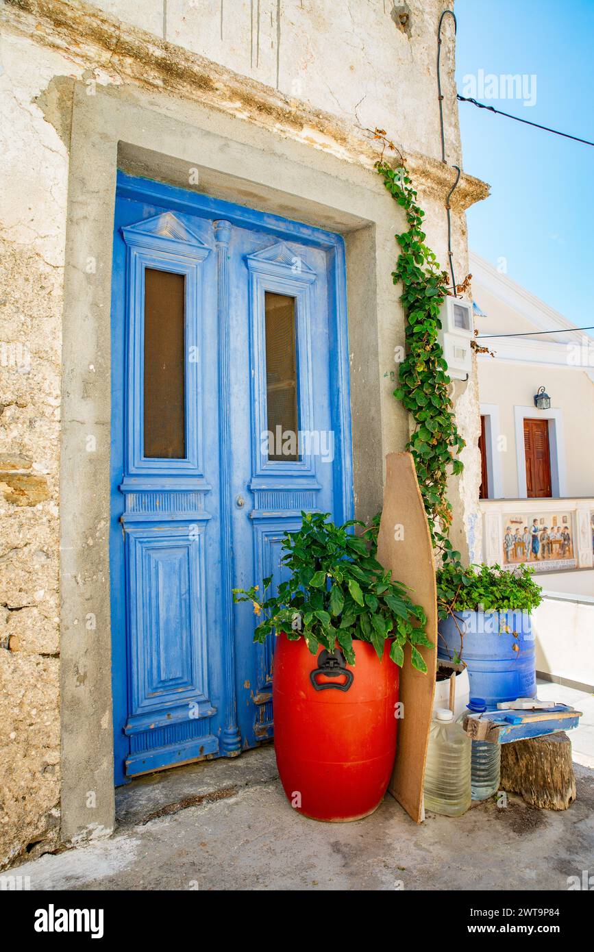 Old Greek blue doors with a red flower pot in the Greek Island of ...