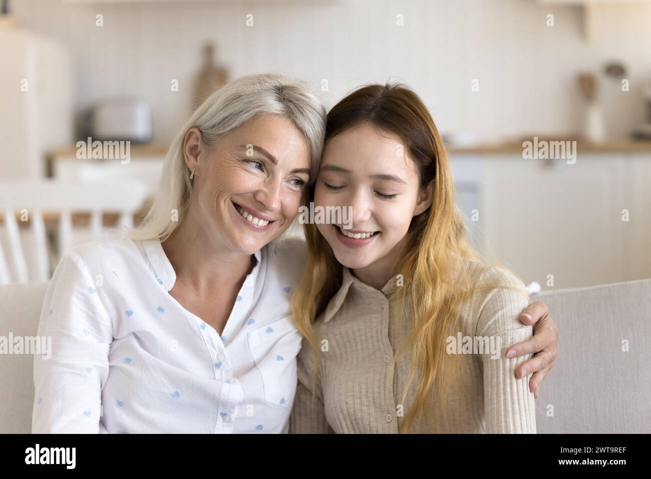 Loving mother hugs her adolescent daughter sit together on sofa Stock Photo - Alamy