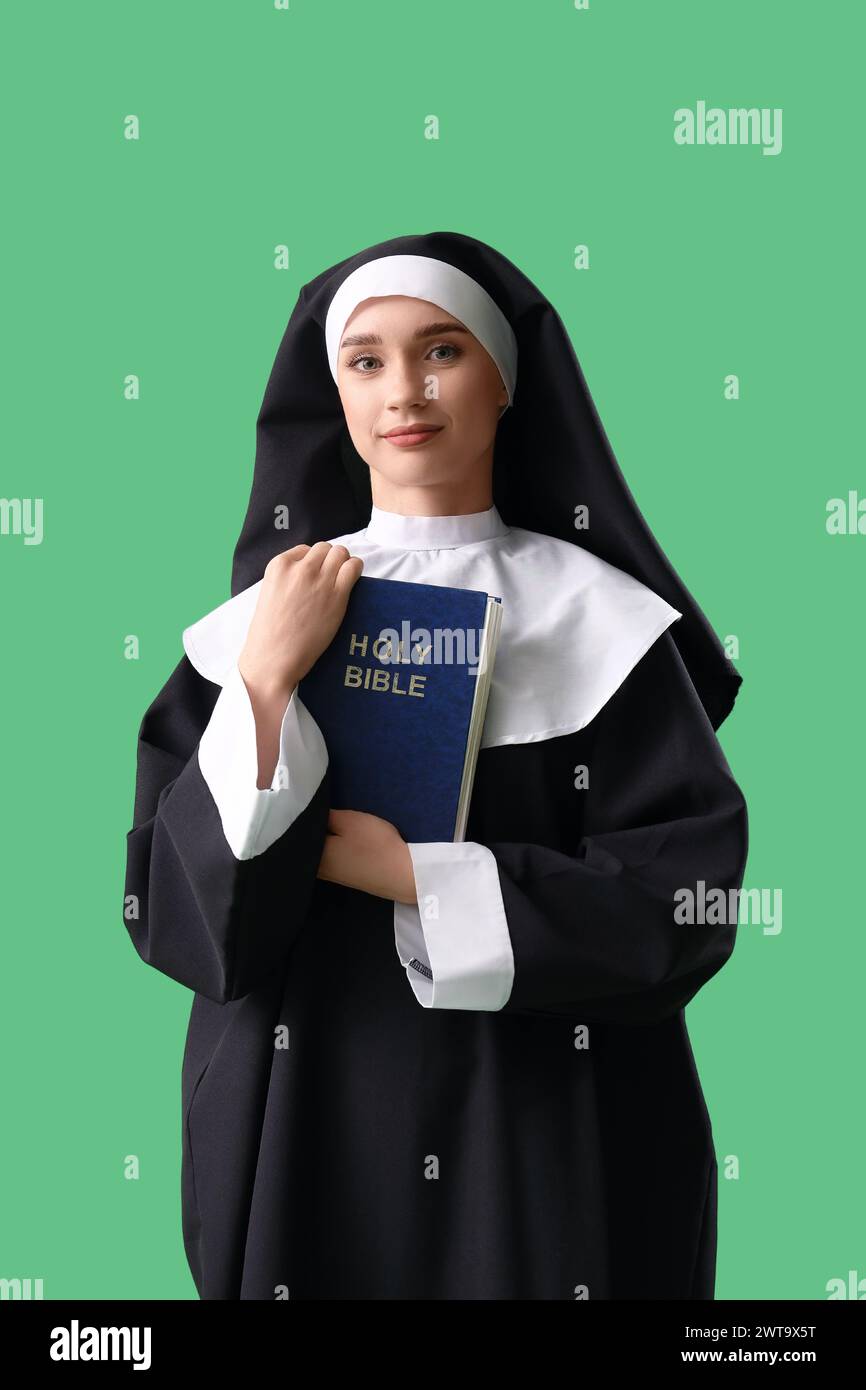 Portrait of nun with holy Bible on green background Stock Photo - Alamy