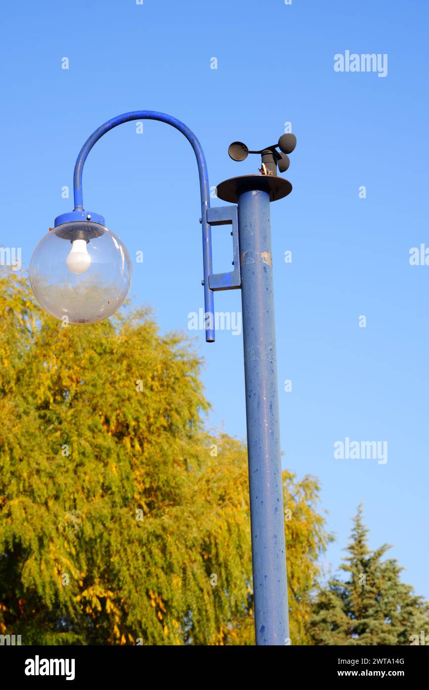 Blue street lamp with anamometer with blue sky at the background in a ...