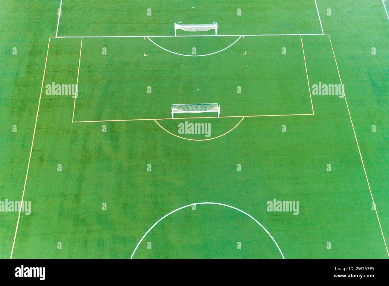 A soccer field with two goals and a bench. The field is green and well ...