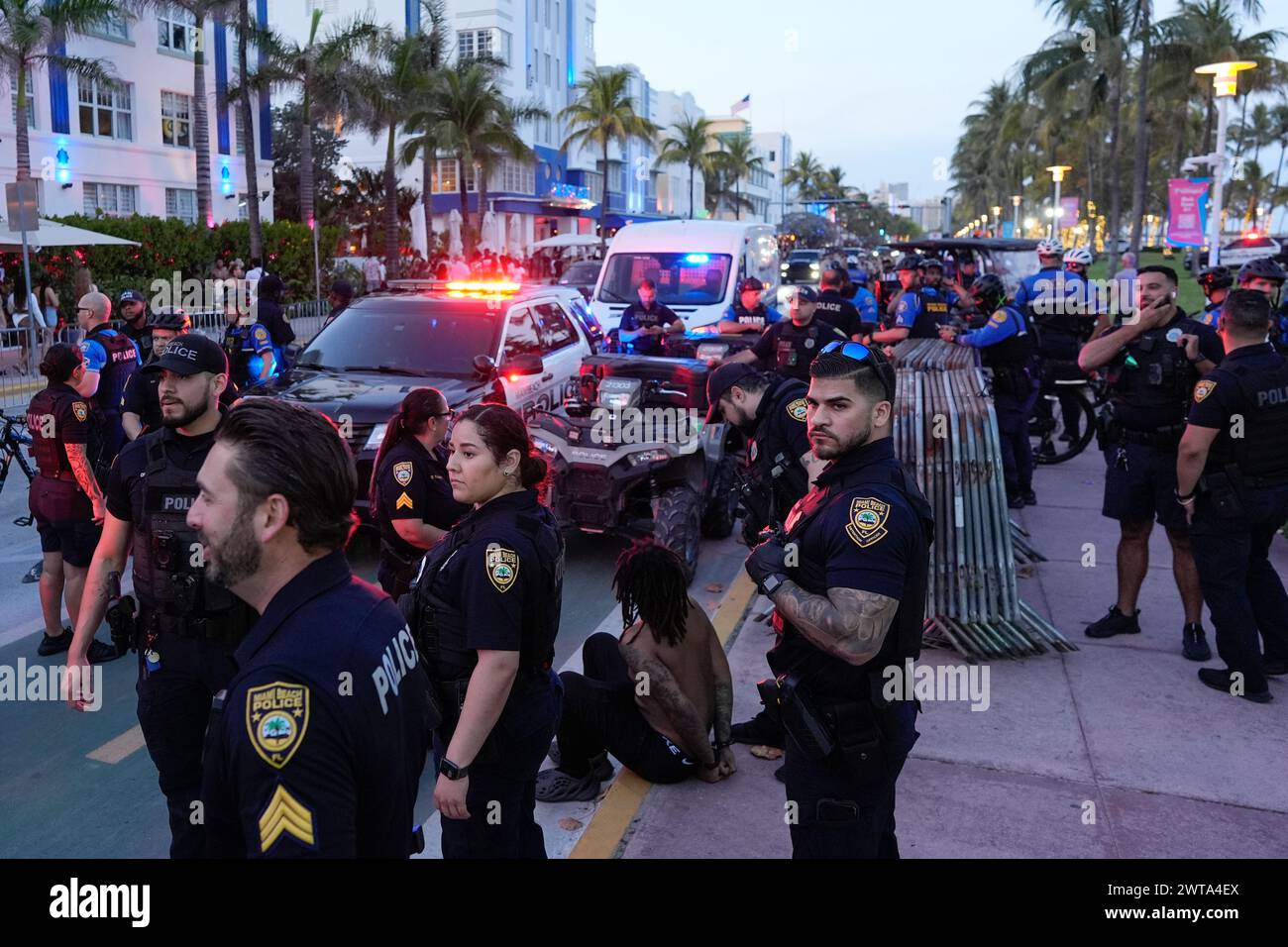 A man is temporarily handcuffed as police, present en masse along Ocean ...