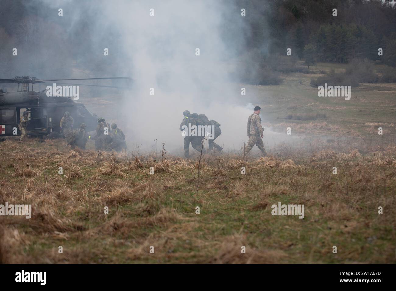German Army soldiers move a simulated casualty through a smoke signal ...