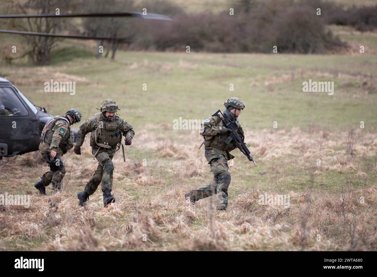 German Army soldiers rush away as a UH-60 Black Hawk helicopter ...
