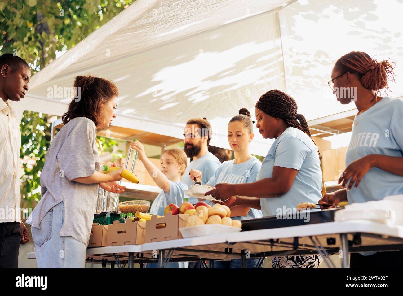 Multicultural hunger relief team distribute free food to the needy ...