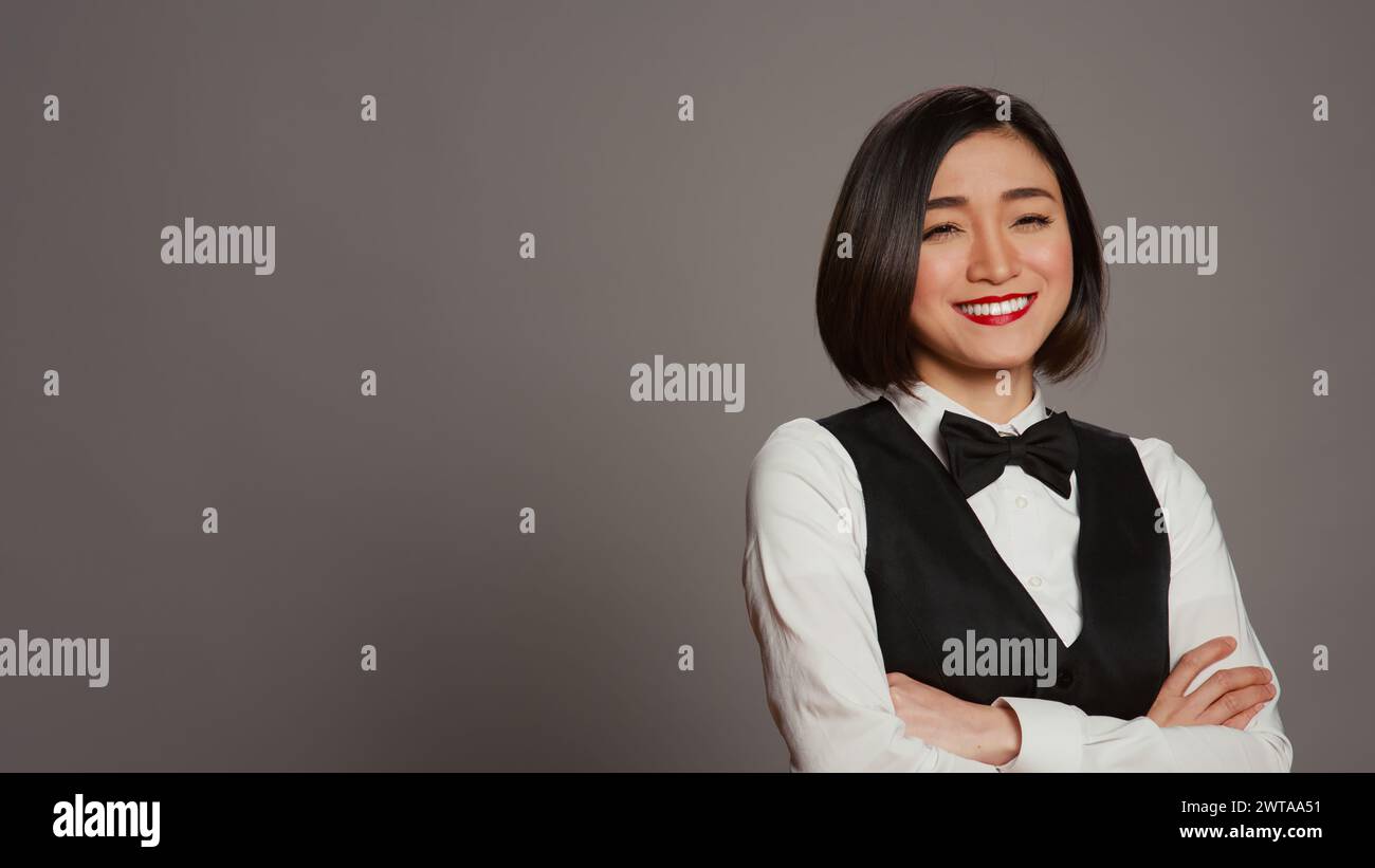 Asian receptionist posing with arms crossed on camera, feeling ...