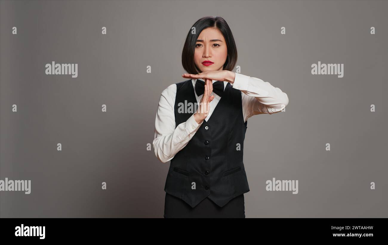 Asian receptionist expressing timeout symbol on camera, showing ...