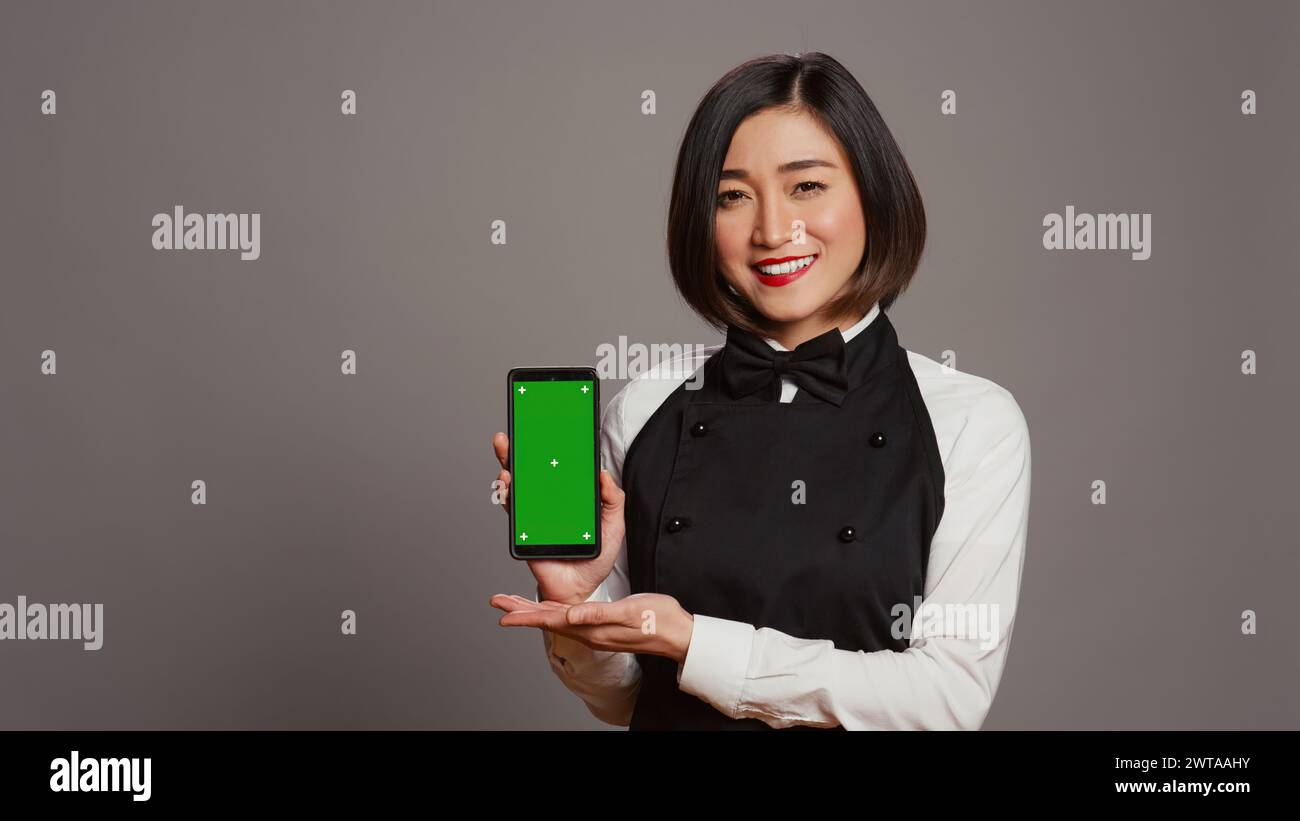 Restaurant hostess presenting smartphone with greenscreen, showing ...