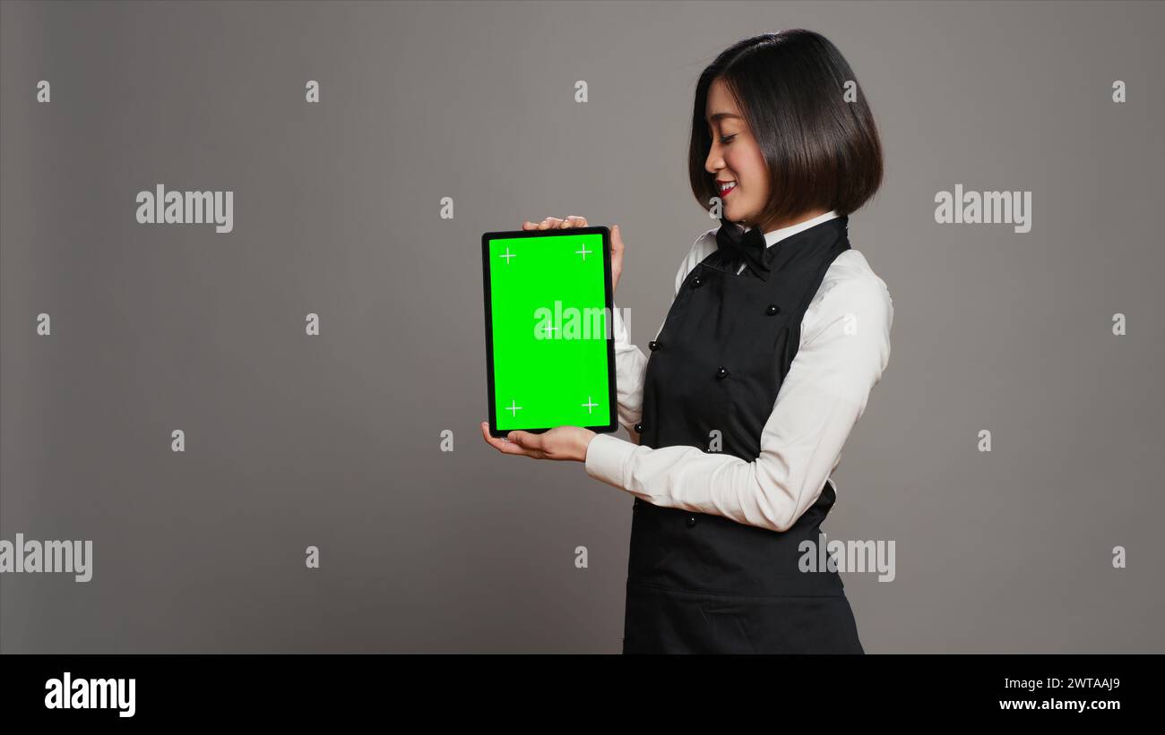 Woman waitress holding tablet with greenscreen display on camera ...
