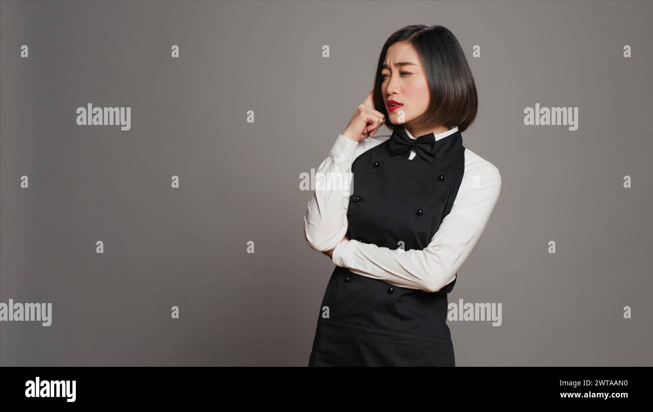 Asian waitress thinking about new menu ideas for restaurant, acting ...